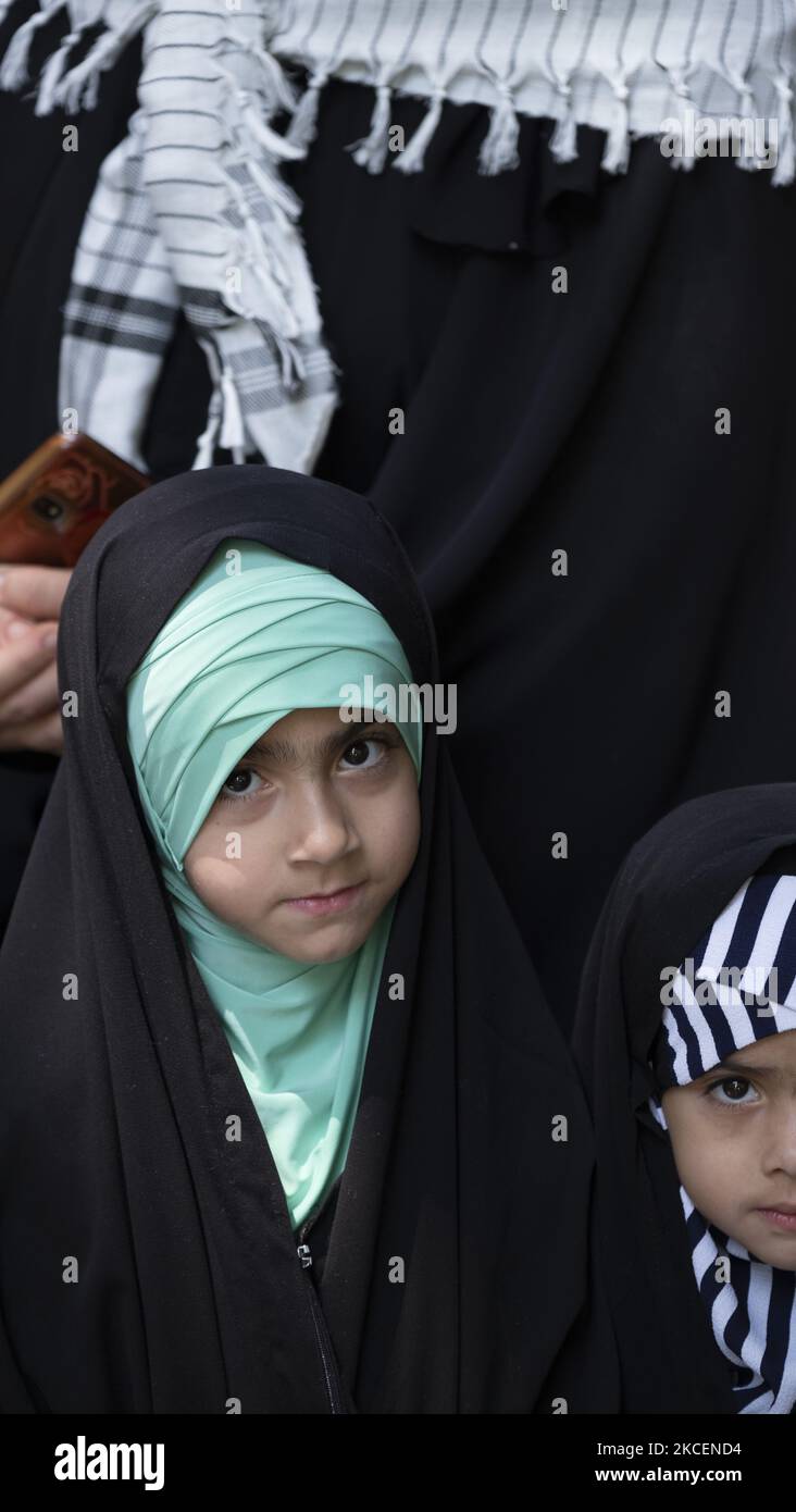 Two Azeri young girls look on as they stand next to their mother before ...