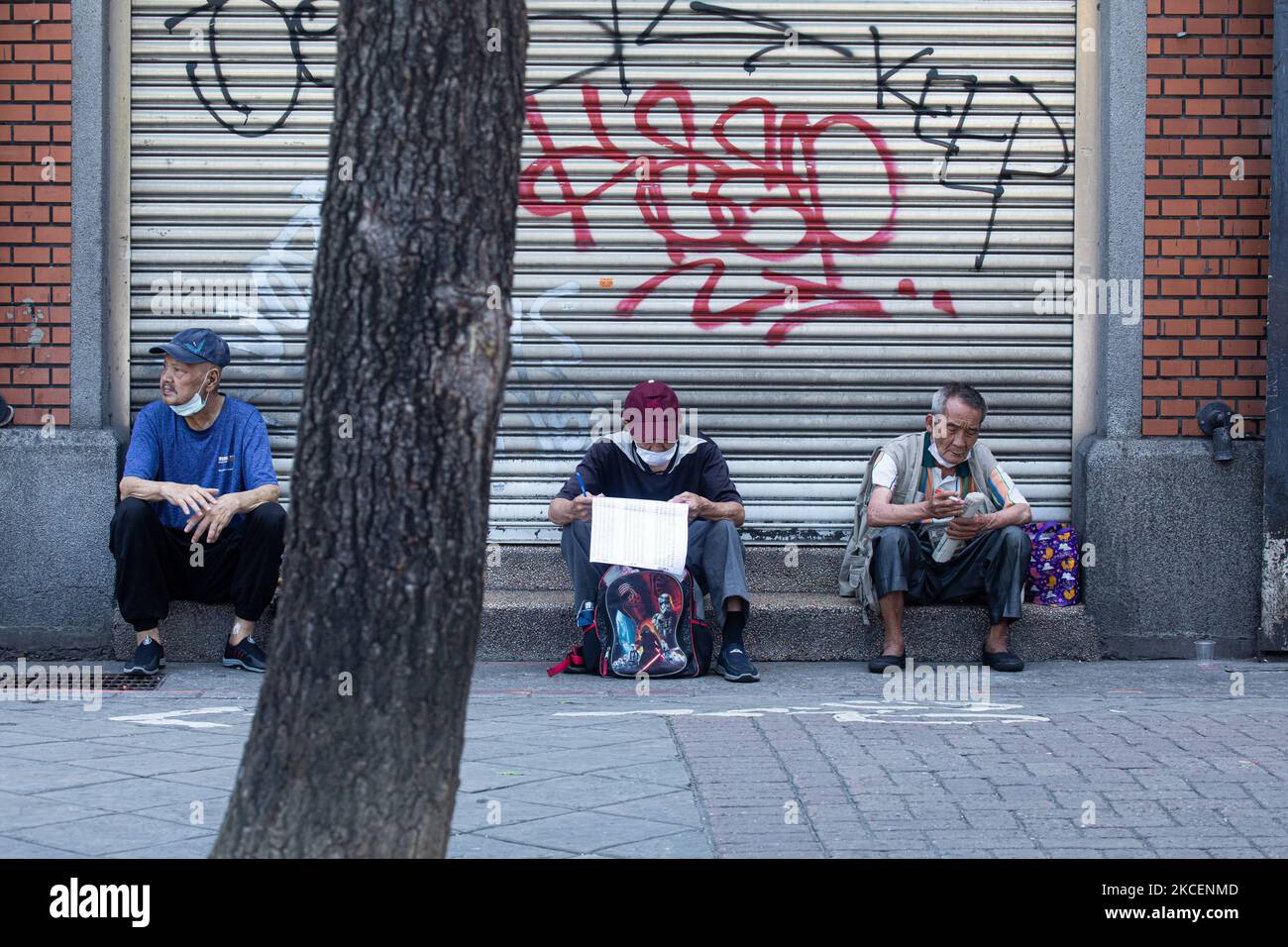 Homeless people sit outside of Longshan Temple in Wanhua District ...