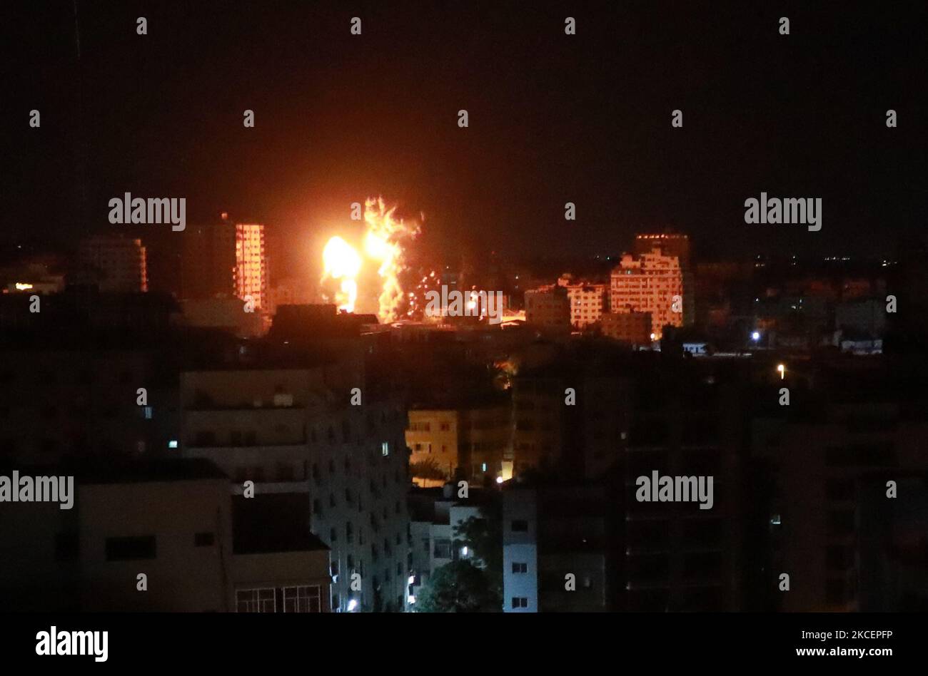 A ball of fire and a plume of smoke rise above buildings in Gaza City ...