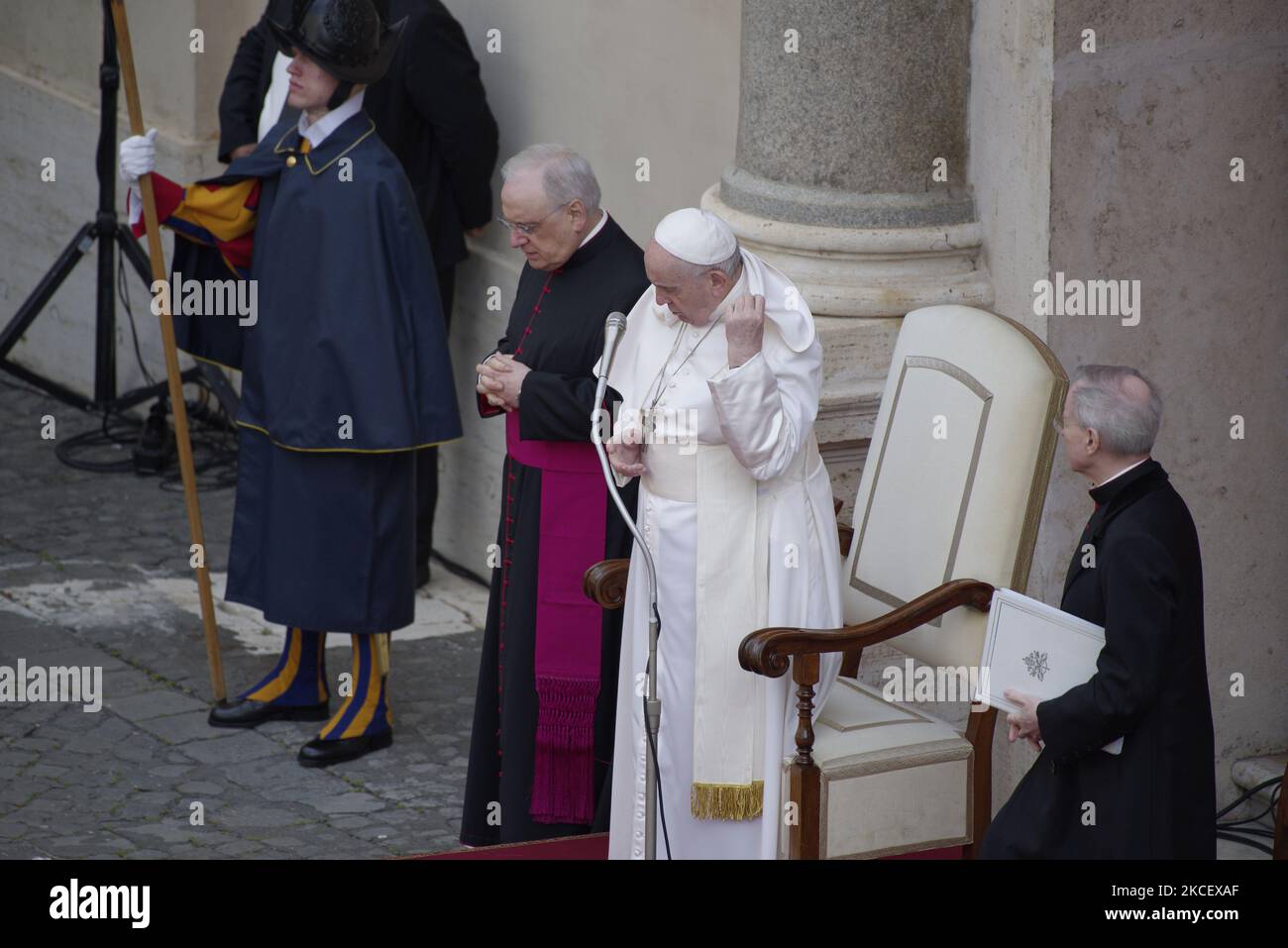 A gust of wind blows the mantle of Pope Francis over his head in the St ...