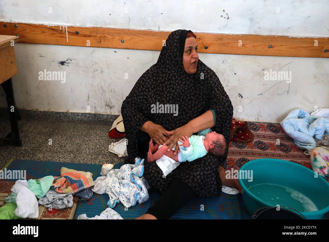 A Palestinian woman holds a one-day-old baby born in a United Nations ...