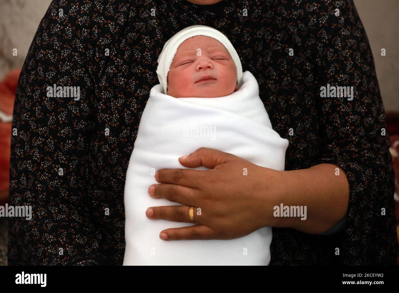 A Palestinian woman holds a one-day-old baby born in a United Nations ...