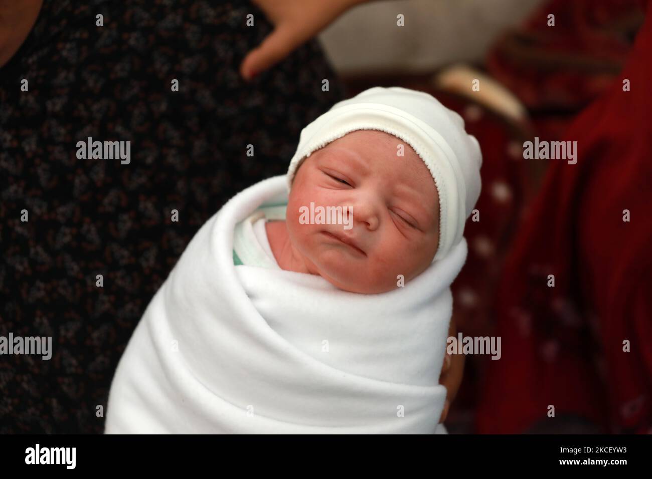 A Palestinian woman holds a one-day-old baby born in a United Nations ...