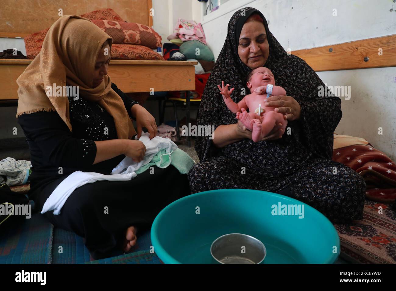 A Palestinian woman baths a one-day-old baby in a United Nations shool ...