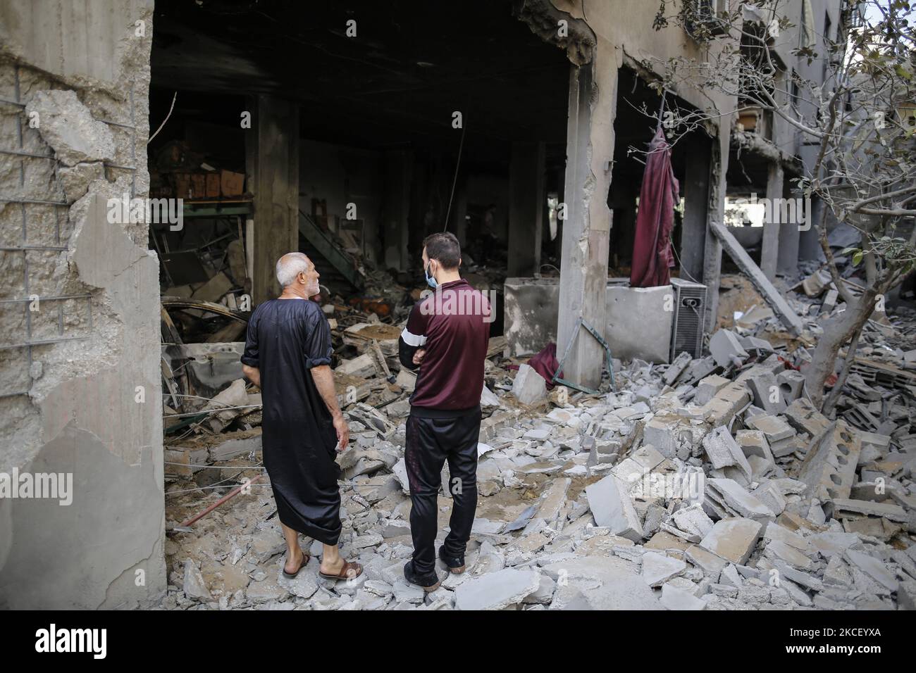 Palestinians inspect buildings damaged after Israeli airstrikes in Gaza ...