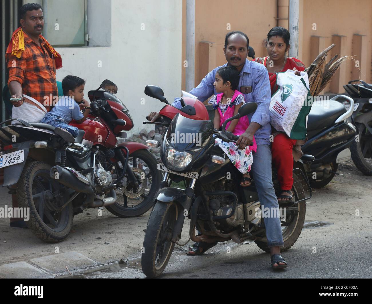 Hindu woman carries a bundle of dried coconut flower sheaths (kothumbu ...