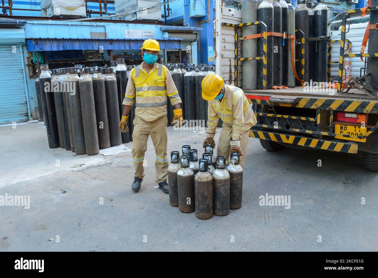 Workers bring in empty canisters of O2 to be filled up at a oxygen ...