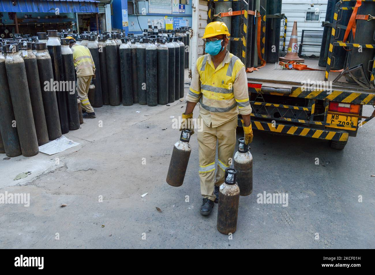 Workers bring in empty canisters of O2 to be filled up at a oxygen ...