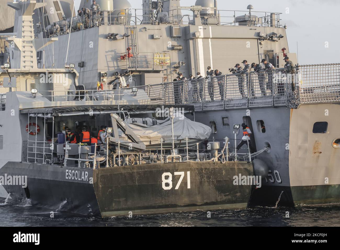 Indonesian fishermen transferred to Navy ship KRI Escolar (left) from ...