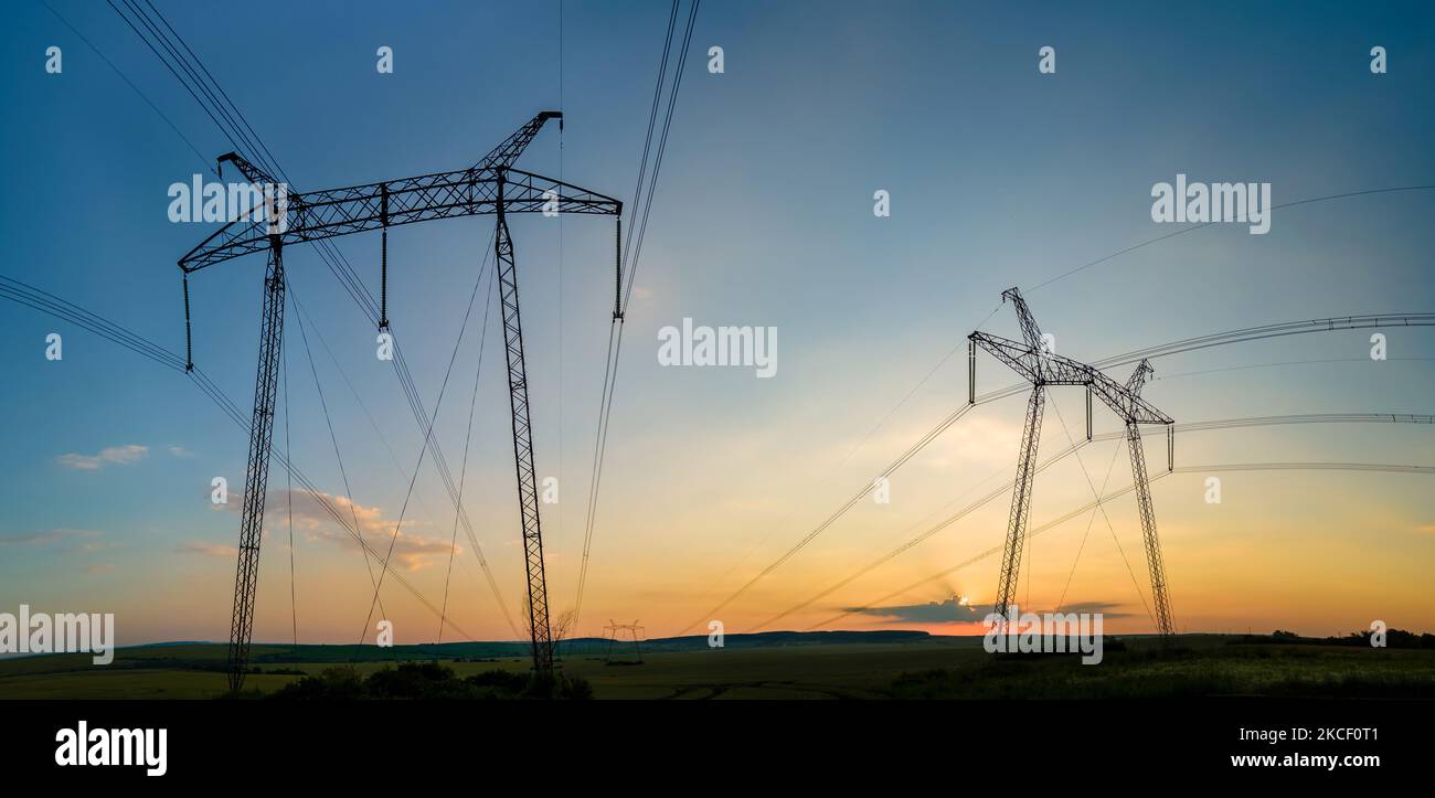 High voltage towers with electric power lines at sunset Stock Photo - Alamy