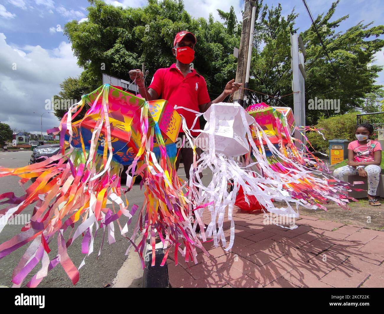 A Sri lankan vendor wearing a face mask sells wesak lanterns as his ...
