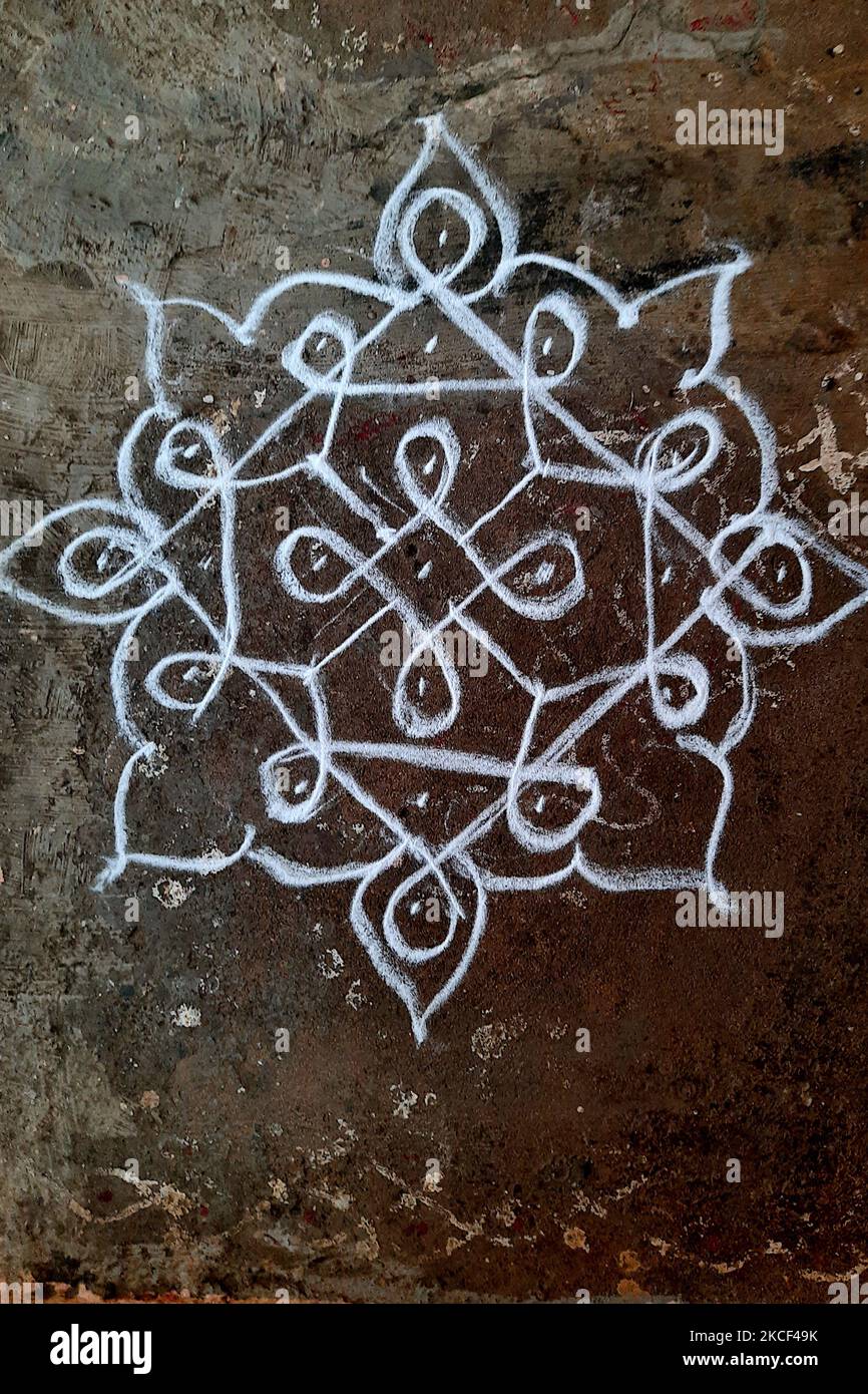Indian tradition of artful rangoli pattern drawn on floor with white ...