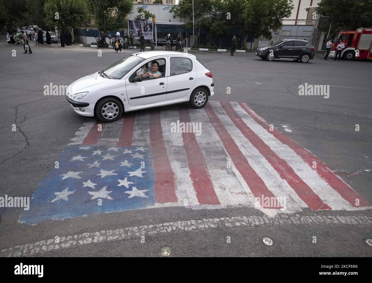 An Iranian driver flashes a Victory sign as he drives his vehicle on ...