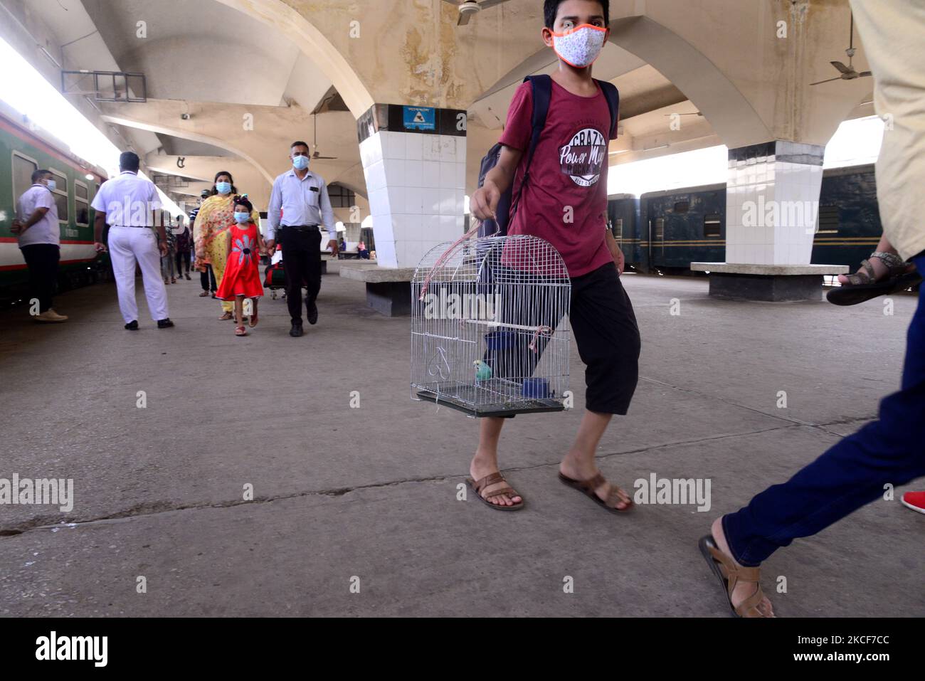 Passenger wearing face masks arrive by a train at a Railway Station ...