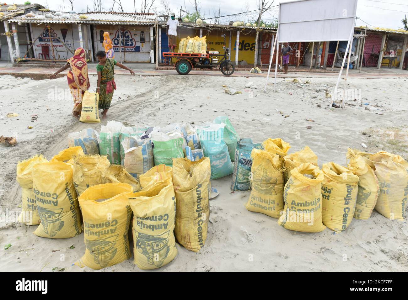 Women seen carrying filled sand bags which will be used as a temporary ...