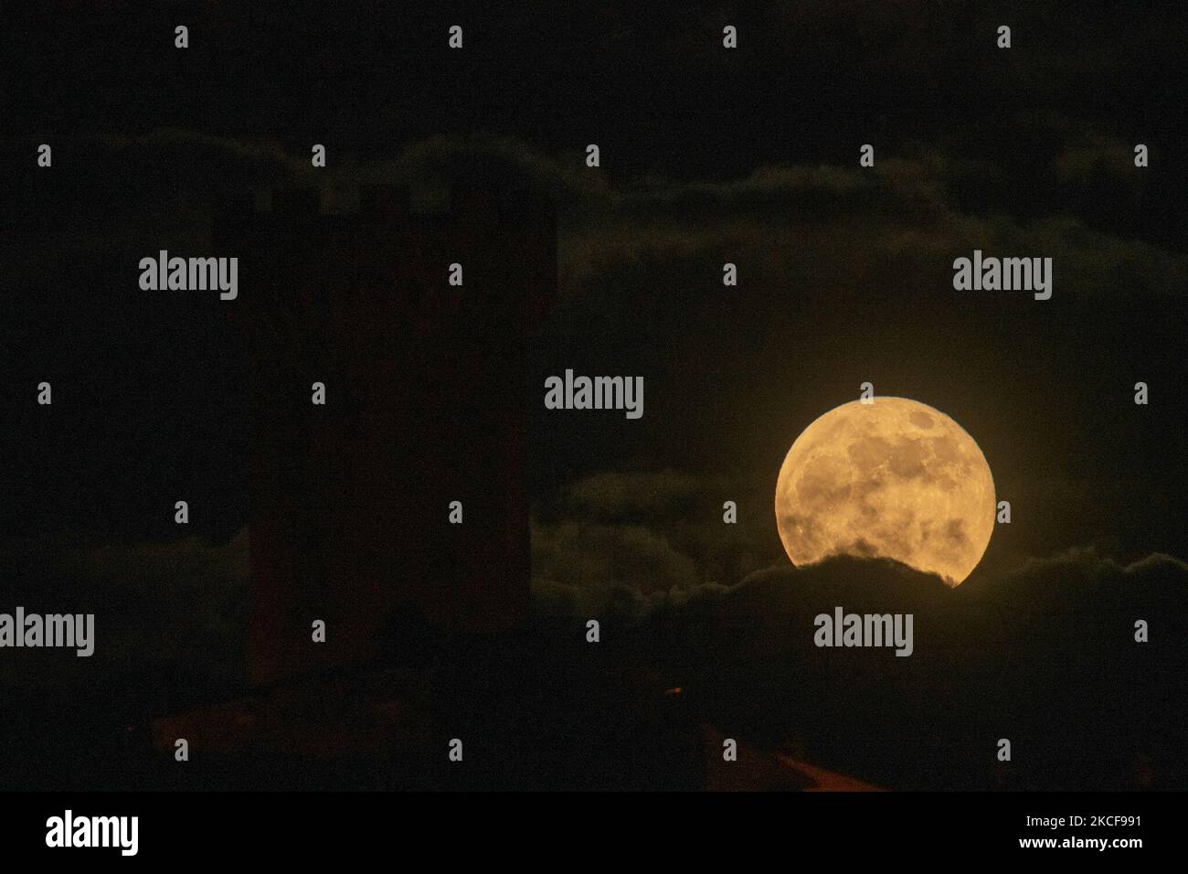 The supermoon (flower Supermoon) rises behind the tower of Santo ...