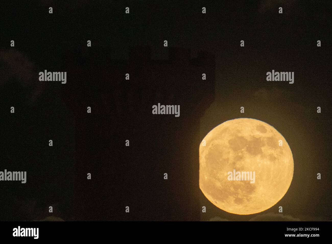 The supermoon (flower Supermoon) rises behind the tower of Santo ...