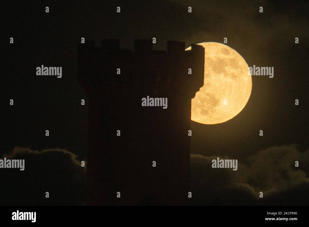 The supermoon (flower Supermoon) rises behind the tower of Santo ...