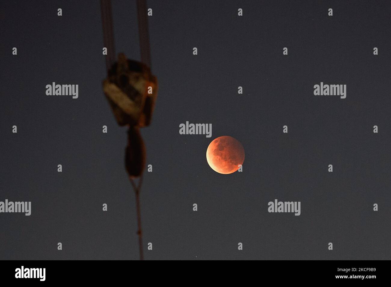The super blood moon is seen behind the crane at a ship breaking yard ...
