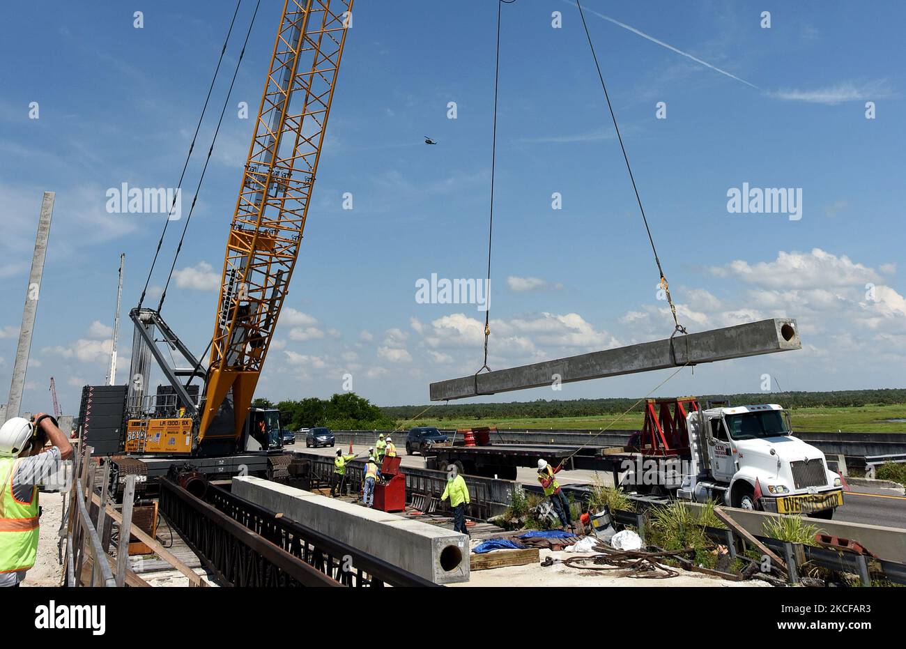 A crane lifts a pile for a bridge over the St. Johns River during the ...