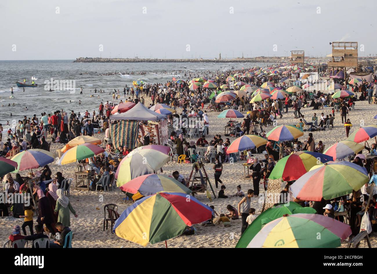 Hundreds of Palestinian people gather in Gaza Beach to cool off on a ...