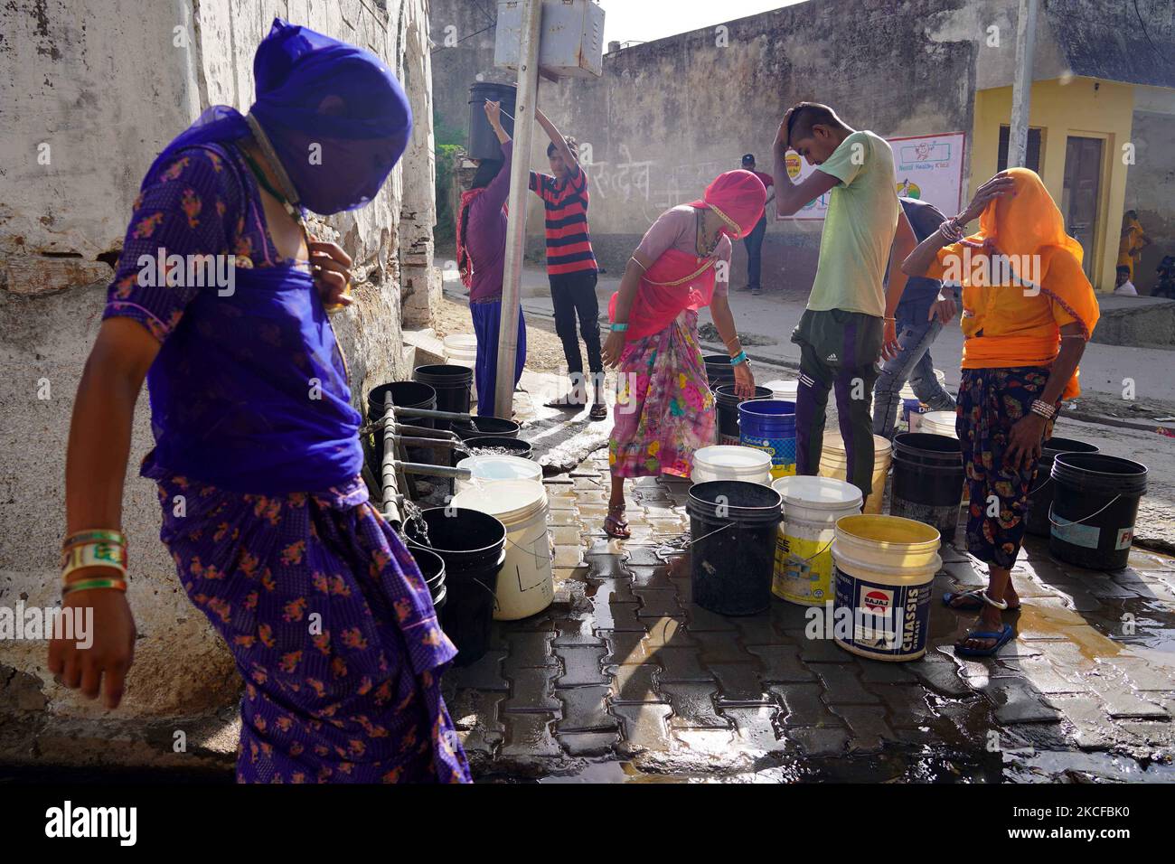 Indian Villagers collects drinking water from a road side water tap ...