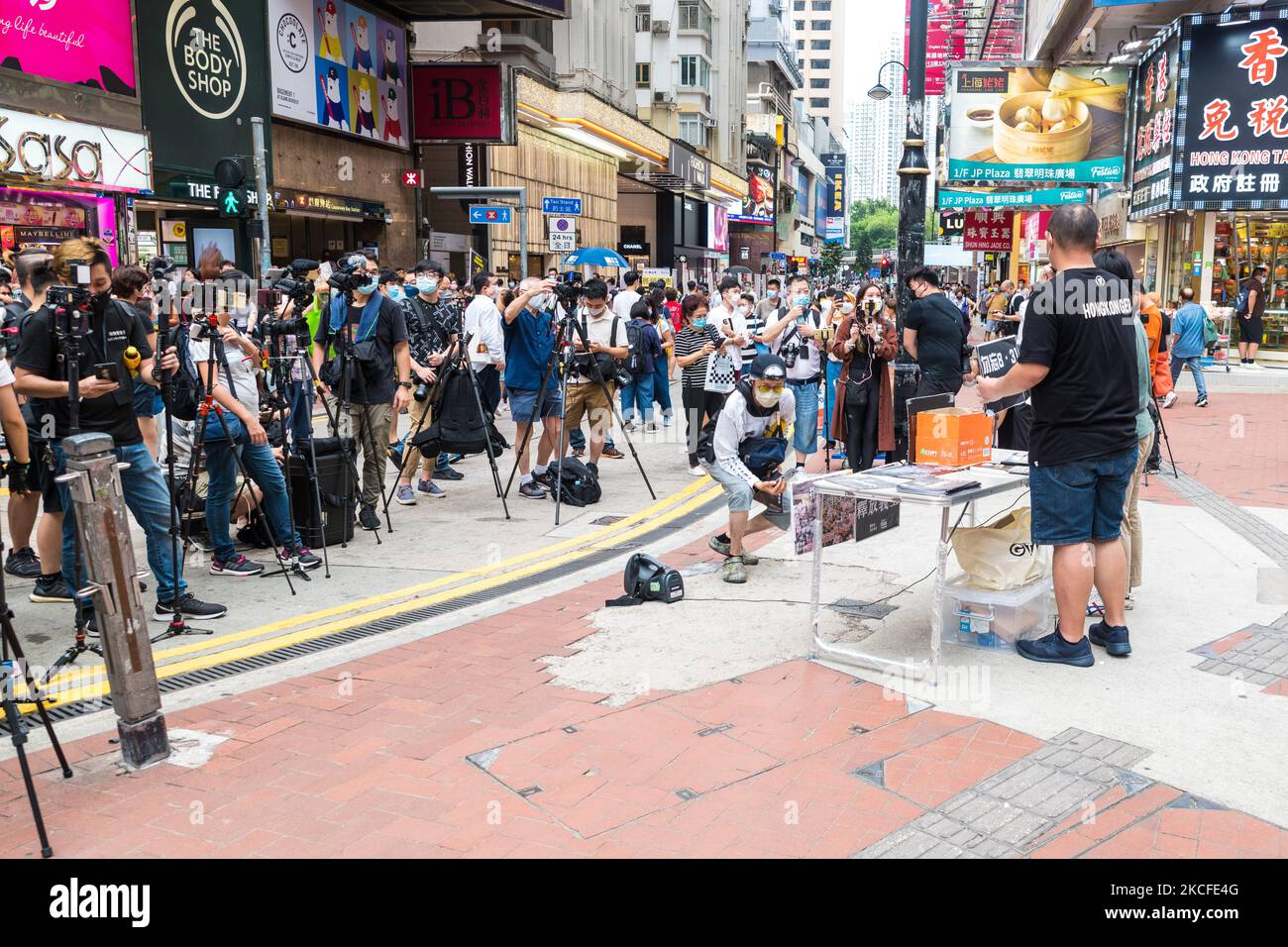 An activist talks to a host of livestreamers in Causeway Bay, under ...