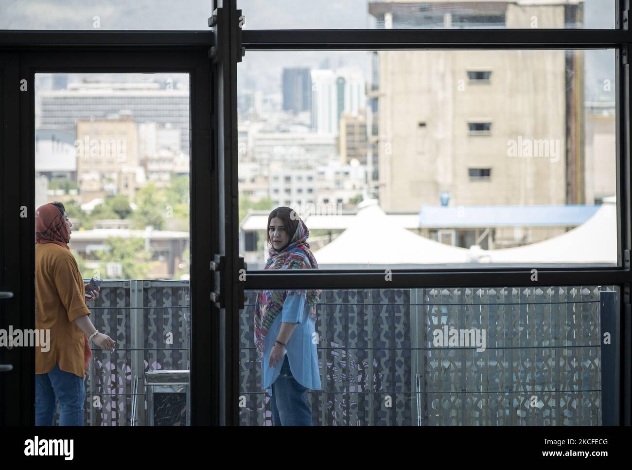 Two Iranian women stand on a balcony of a shopping mall in downtown ...