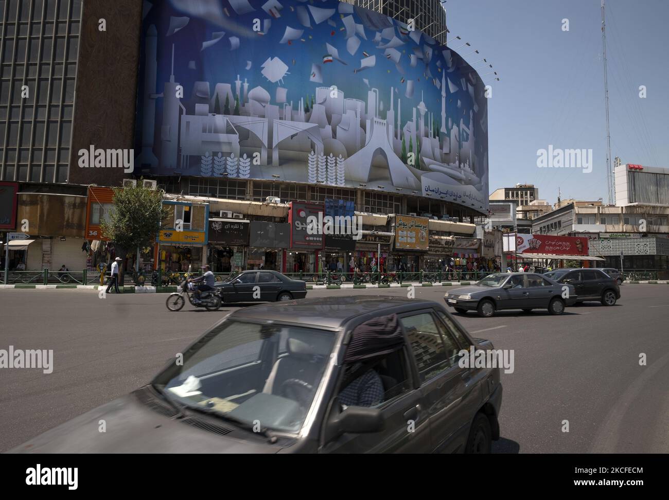Vehicles drive past an electoral billboard in downtown Tehran on May 30 ...