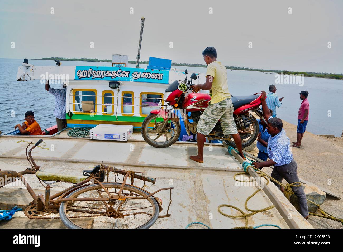 Passengers load a motorbike on a ferry boat at the Kanaki Harbour in the Jaffna region of Sri ...