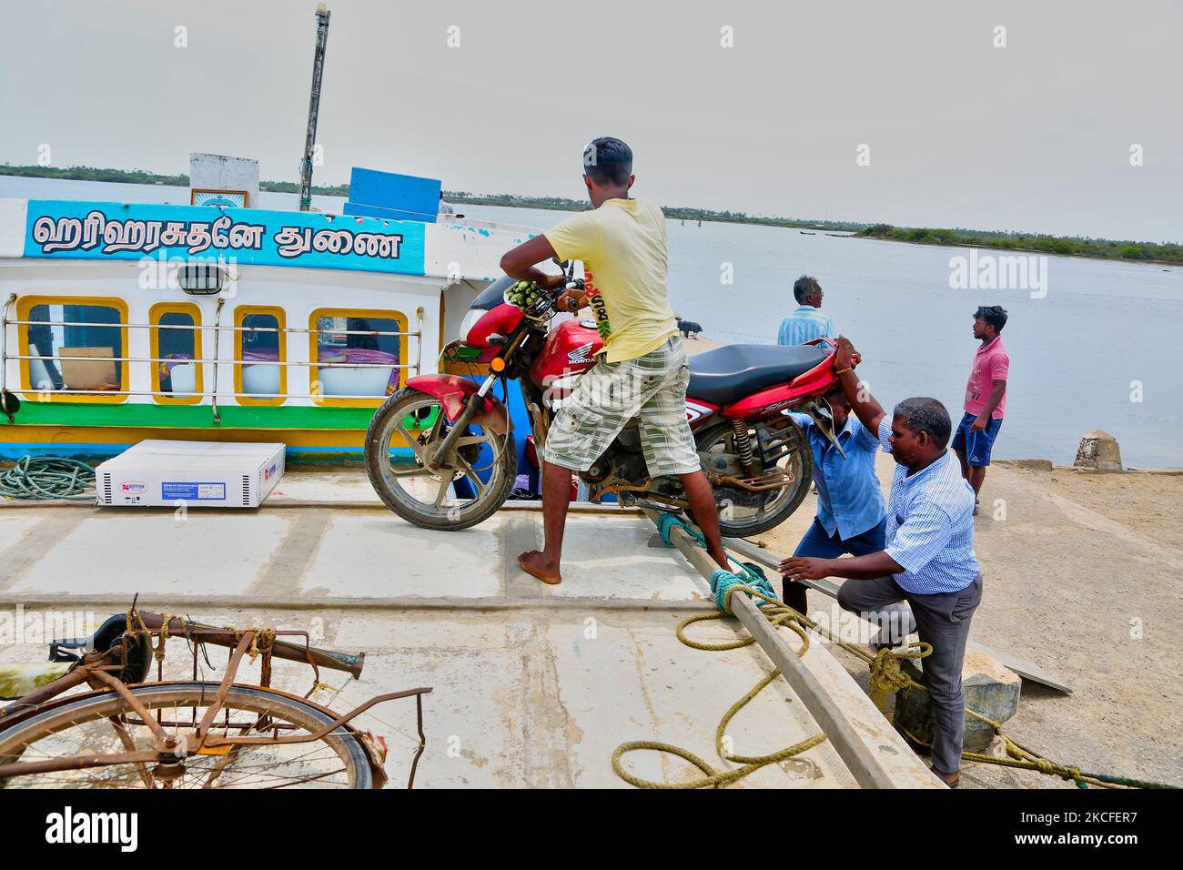 Passengers load a motorbike on a ferry boat at the Kanaki Harbour in the Jaffna region of Sri ...