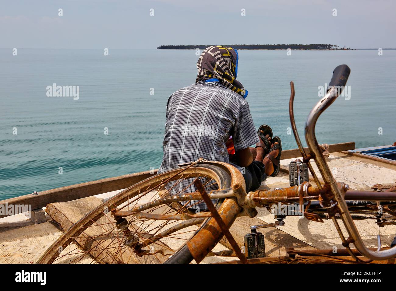 Passenger sits on the roof of a ferry boat while travelling to Analaitivu Island in the Jaffna ...