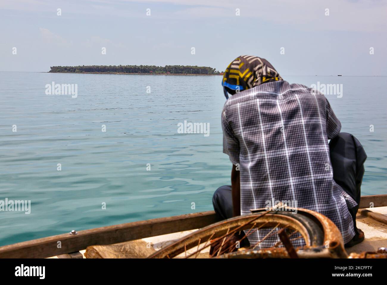 Passenger sits on the roof of a ferry boat while travelling to Analaitivu Island in the Jaffna ...