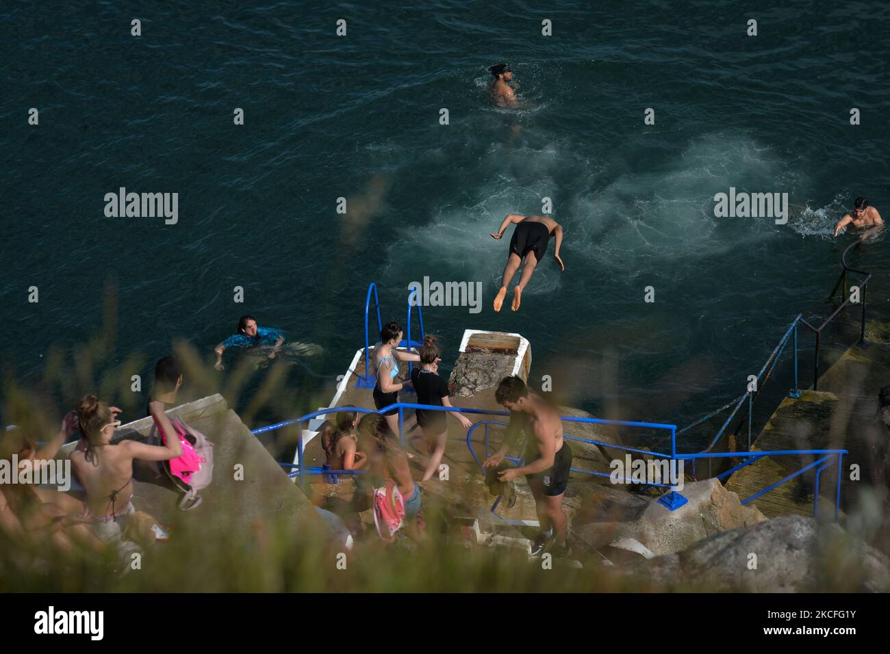 A swimmer jumps into the sea at the Vico bathing place, Hawk Cliff, in ...