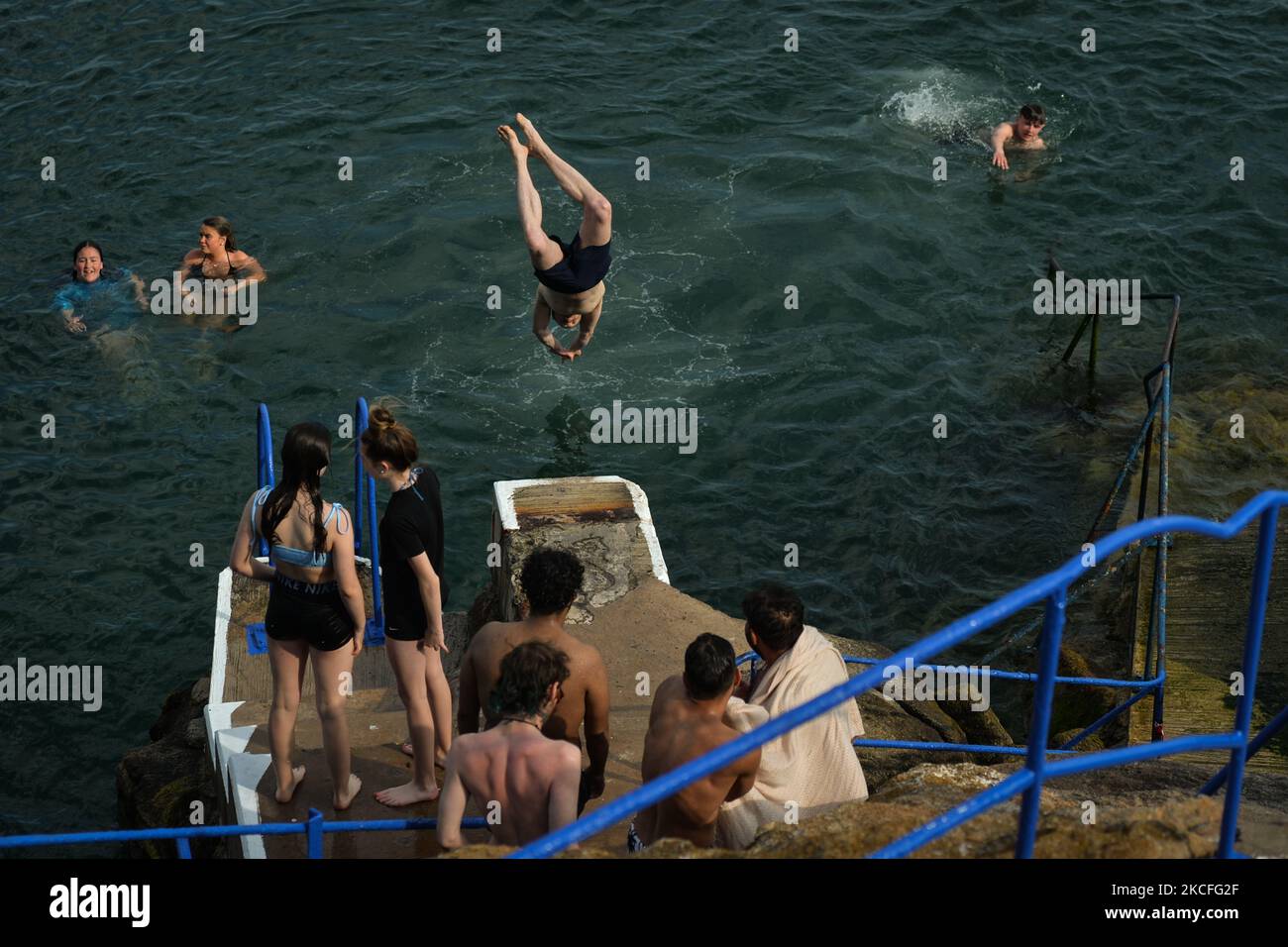 A swimmer jumps into the sea at the Vico bathing place, Hawk Cliff, in ...