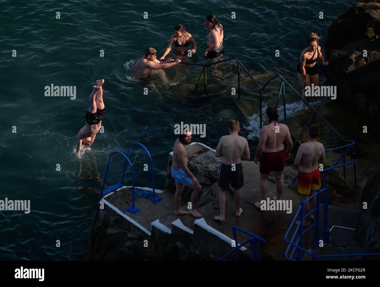 A swimmer jumps into the sea at the Vico bathing place, Hawk Cliff, in ...
