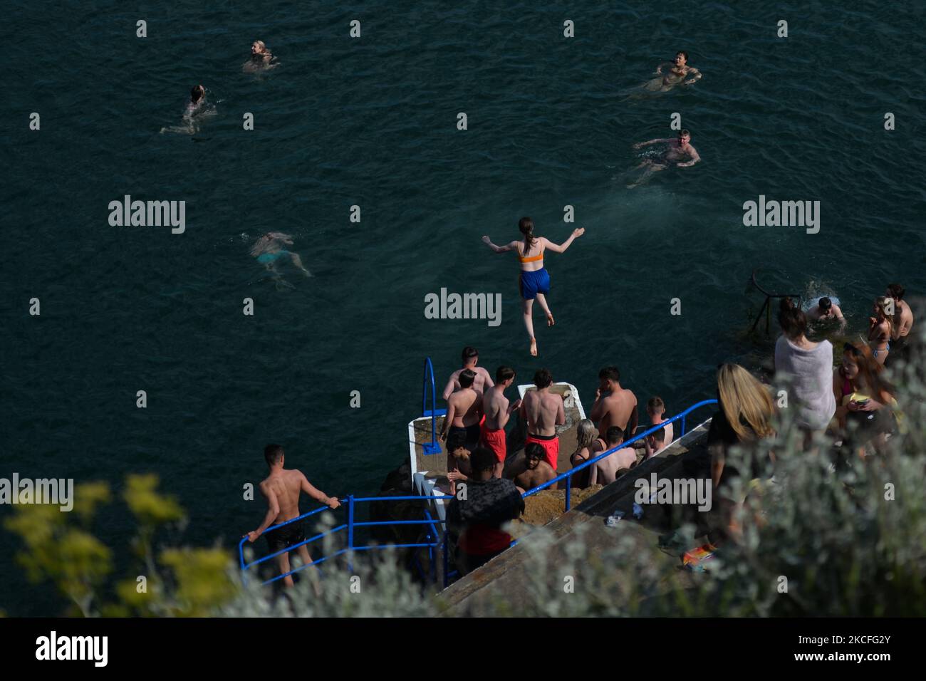 A swimmer jumps into the sea at the Vico bathing place, Hawk Cliff, in ...