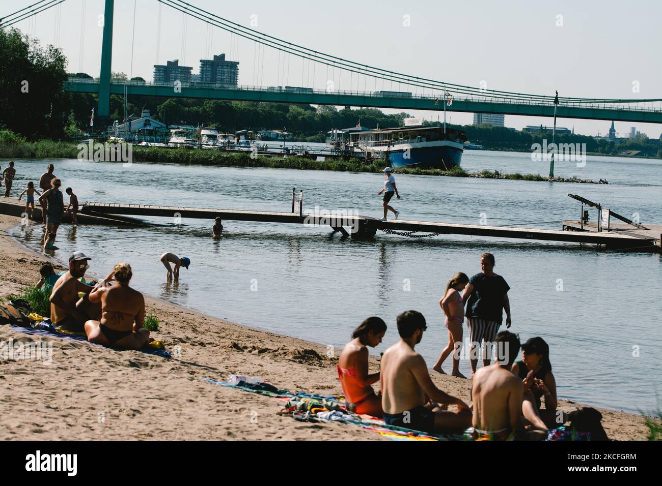 people enjoy the sunny summer weather at Rodenkirche beach in Cologne ...