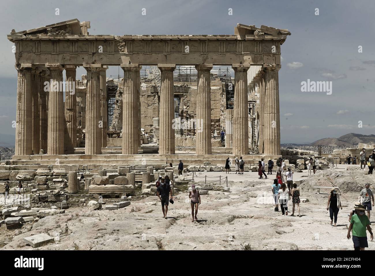 Tourist walk in front the ancient temple of Parthenon at the Acropolis ...