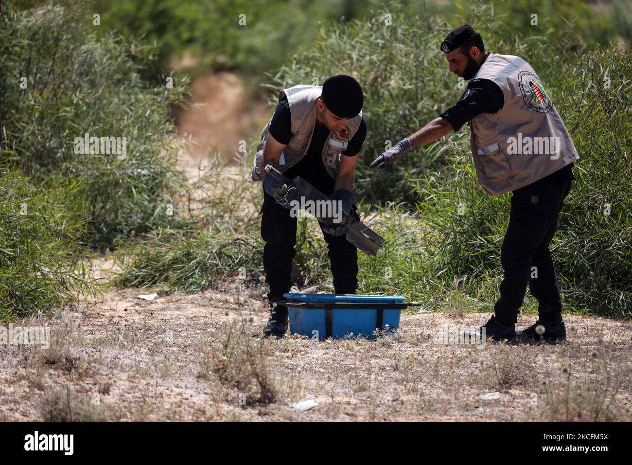 Explosives experts of Hamas pack up an unexploded projectile from the aftermath of the May 2021 ...