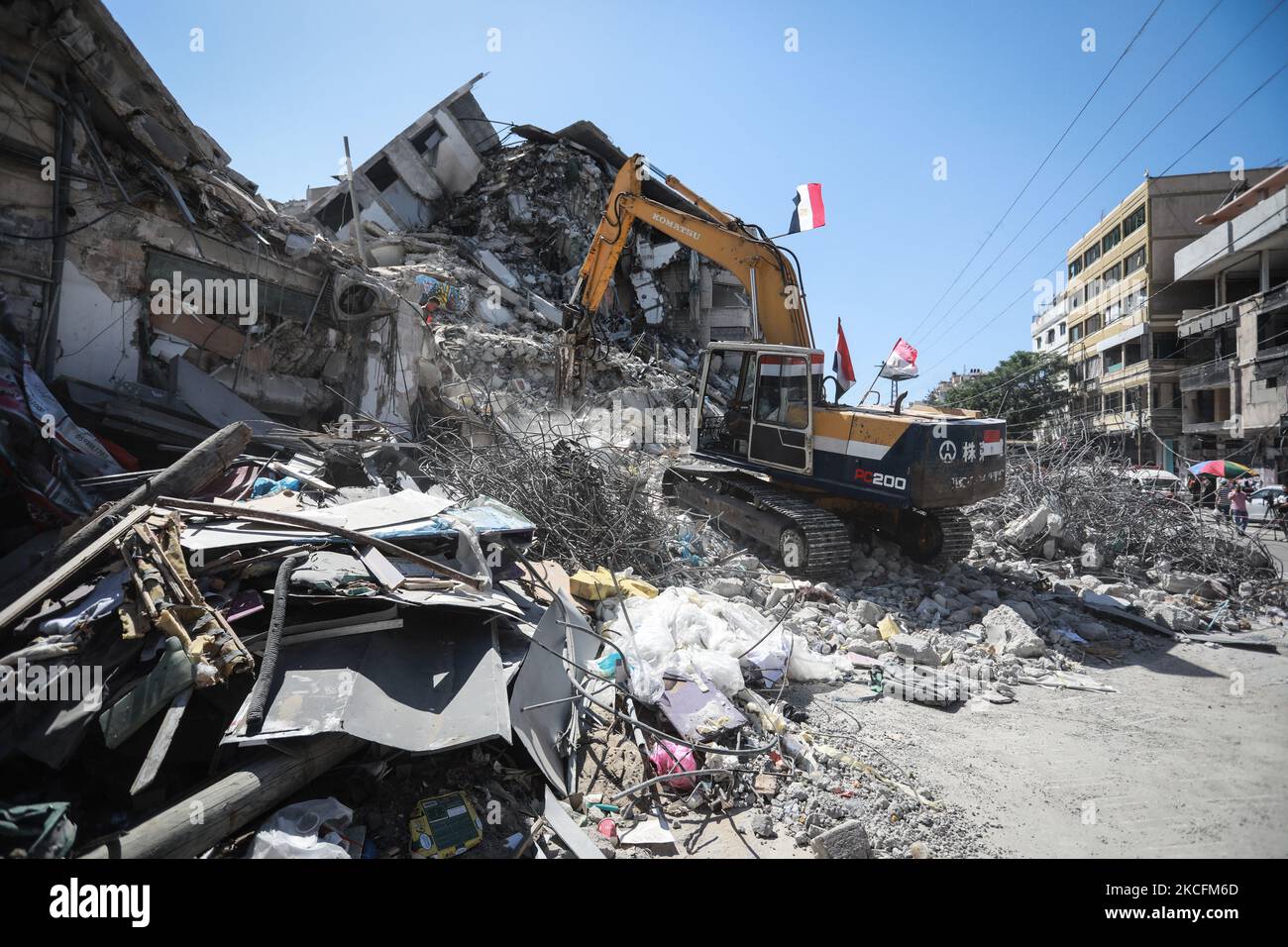 An excavator run by an Egyptian team clears up the rubble of Al-Shorouk ...