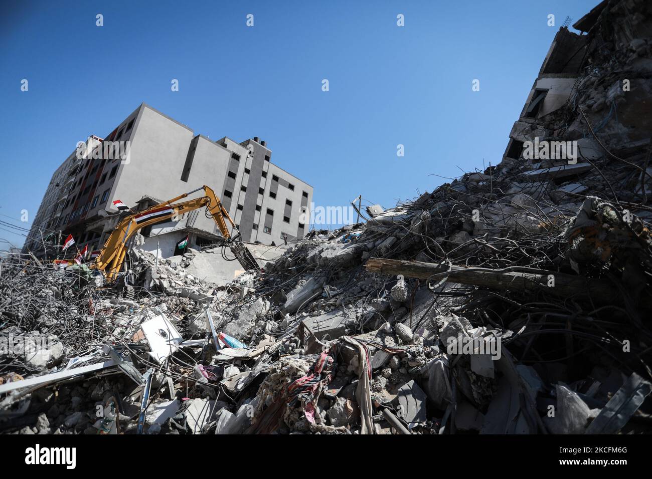 An excavator run by an Egyptian team clears up the rubble of Al-Shorouk ...
