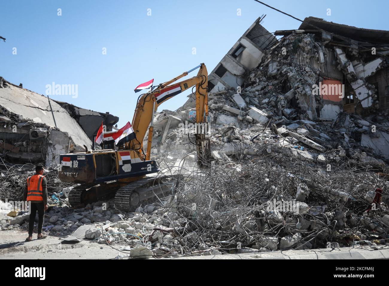 An excavator run by an Egyptian team clears up the rubble of Al-Shorouk ...