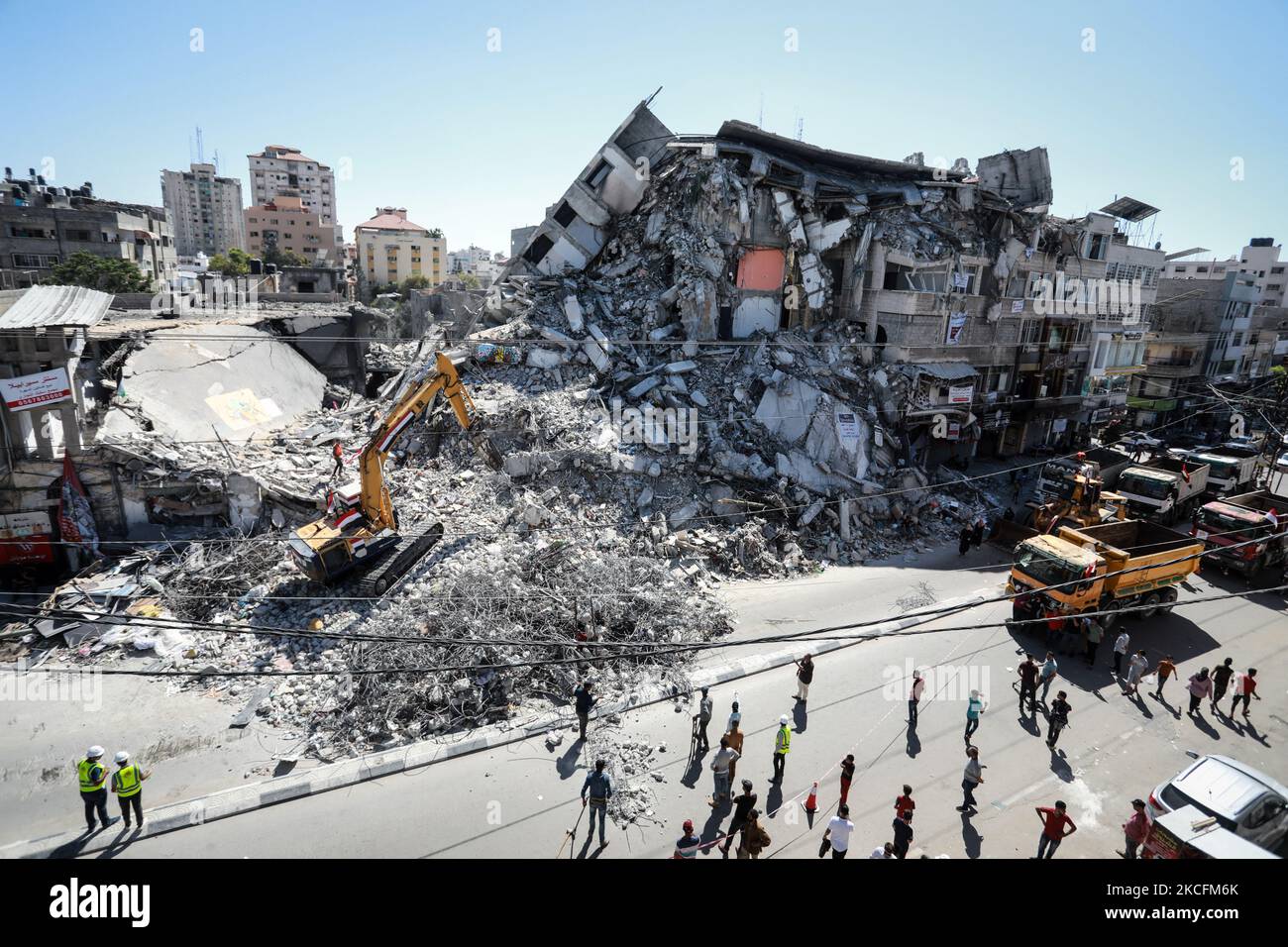 An excavator run by an Egyptian team clears up the rubble of Al-Shorouk ...