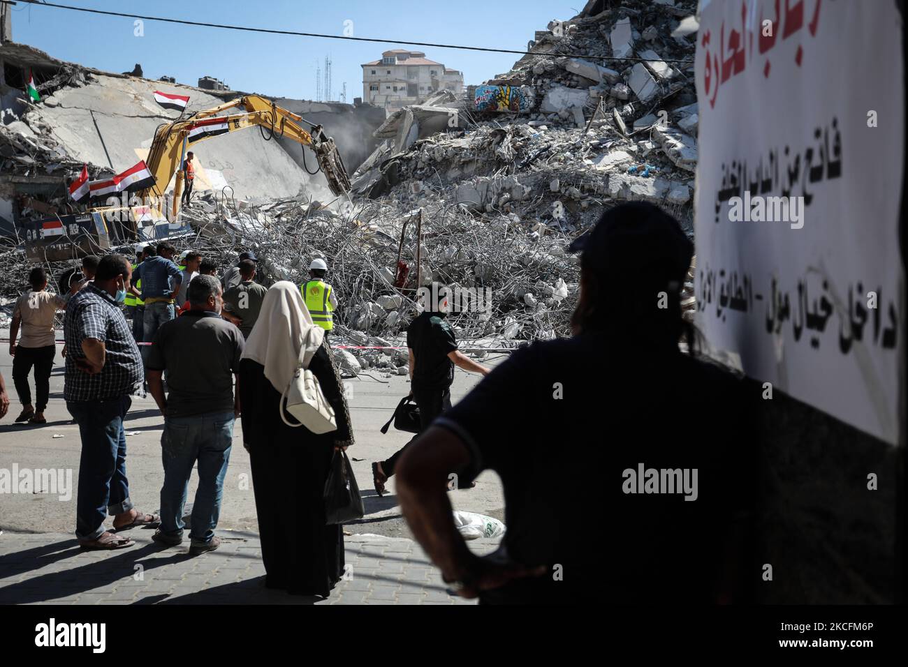An excavator run by an Egyptian team clears up the rubble of Al-Shorouk ...