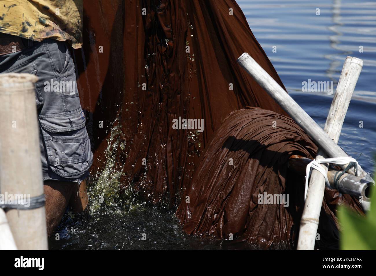 Worker wash colored batik cloth in the Asem Binatul river flow, in ...