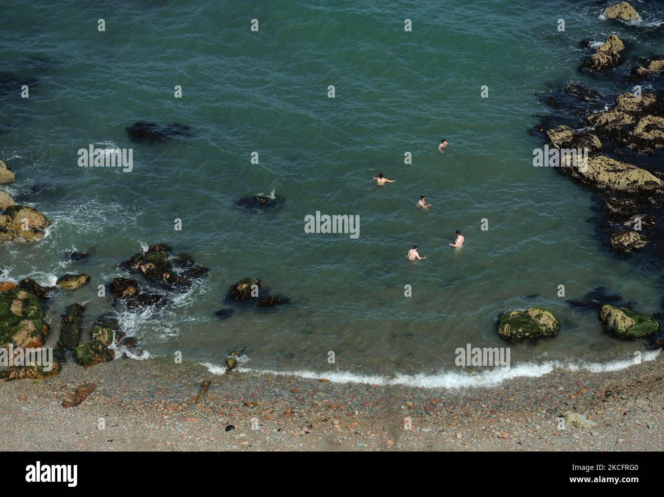 People enjoy swimming at a tiny hidden beach near the Baily Lighthouse ...