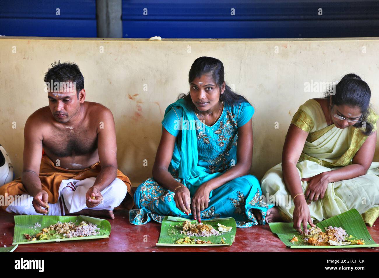 Tamil Hindu devotees eat a traditional vegetarian lunch served on a ...