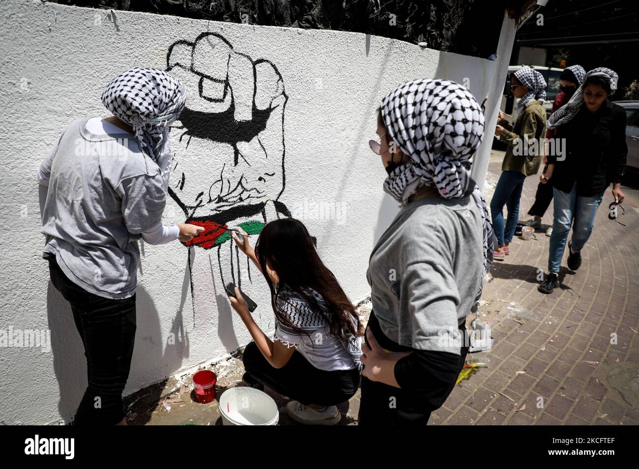 Palestinian artists paint murals in Gaza City on June 8, 2021. (Photo ...