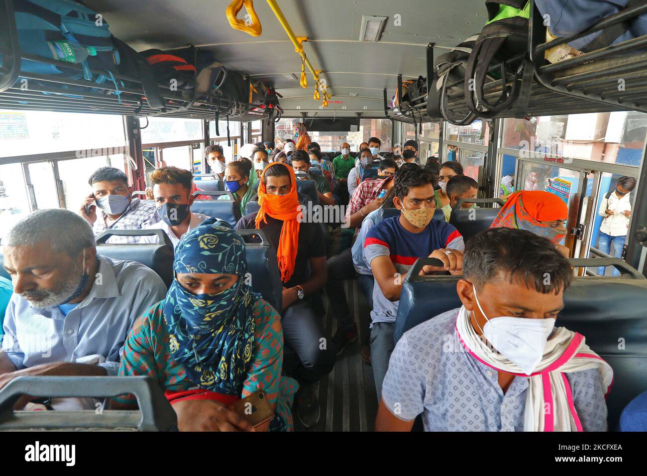 Passengers sit in the bus as they move towards their native place ...